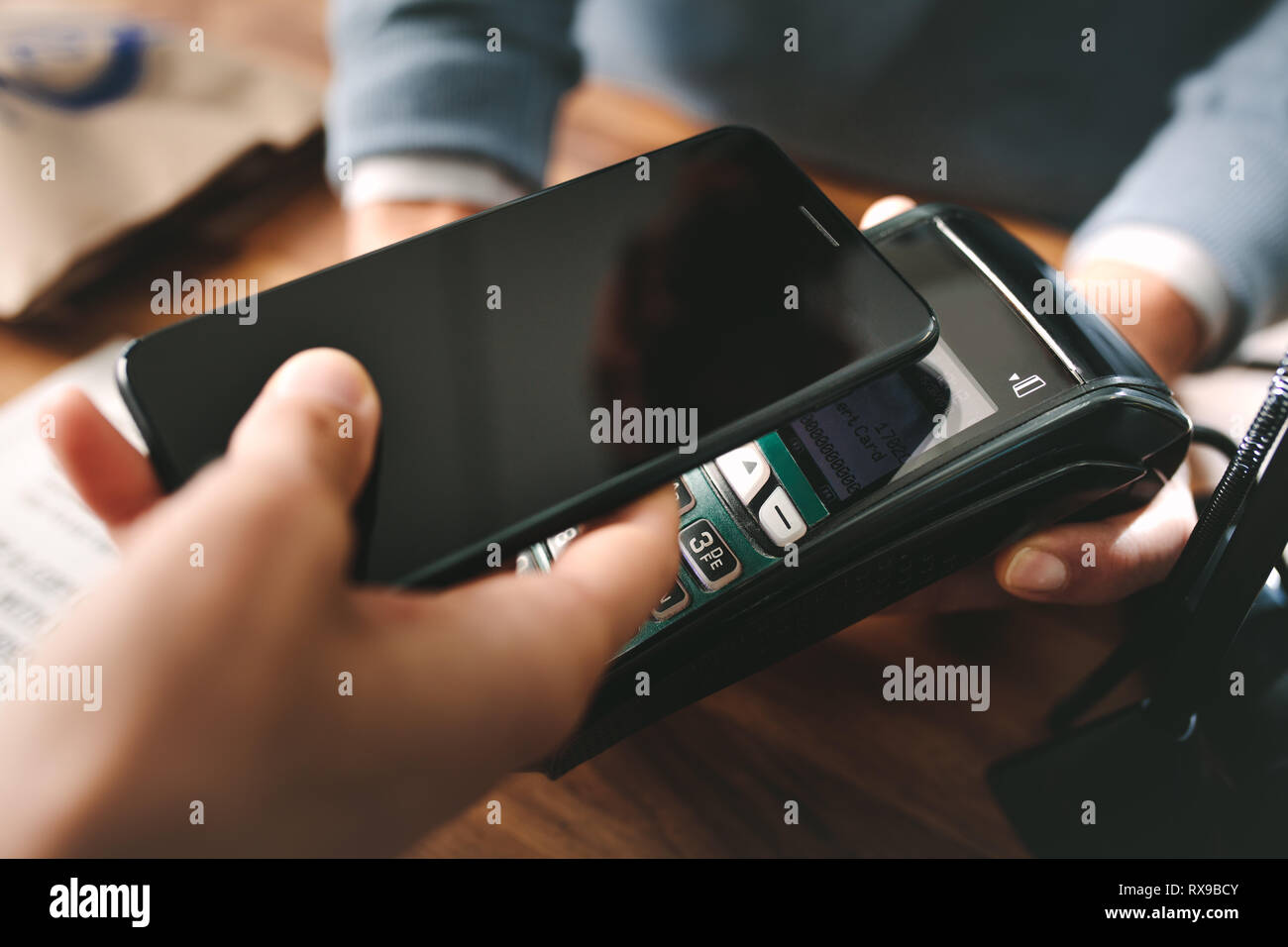 Customer paying bill through smartphone using NFC technology in ...