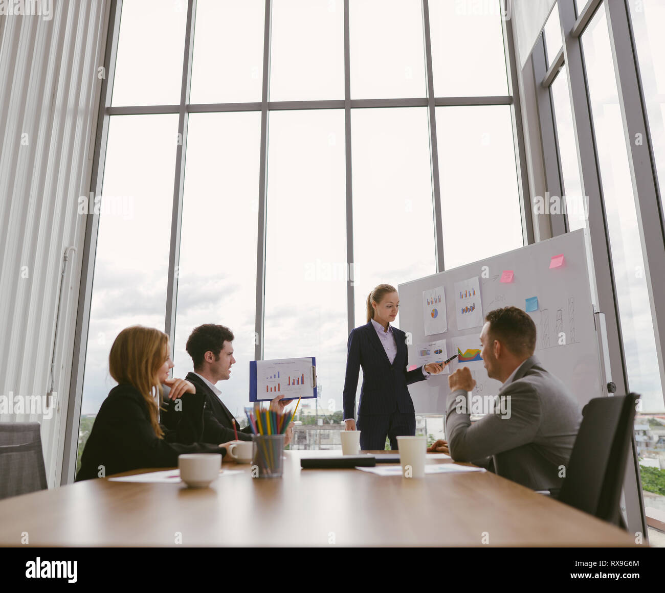 businesswoman standing and making presentation in meeting room office ...