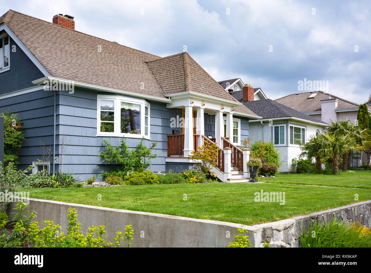 Average residential house with lush front yard lawn on land terrace ...