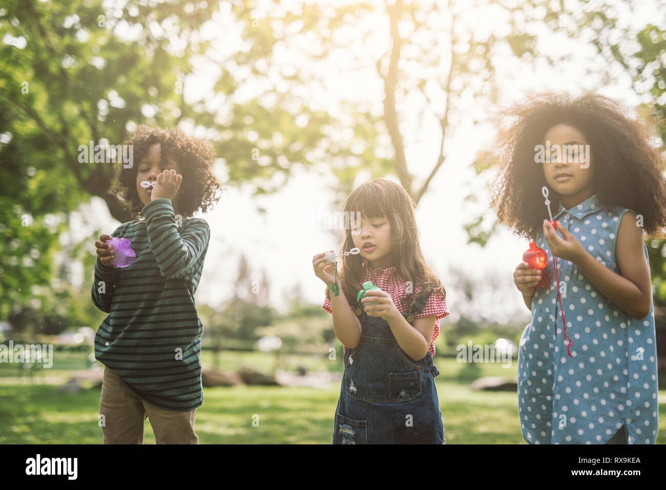 Kids playing Blowing Bubbles Together at the Field Stock Photo - Alamy