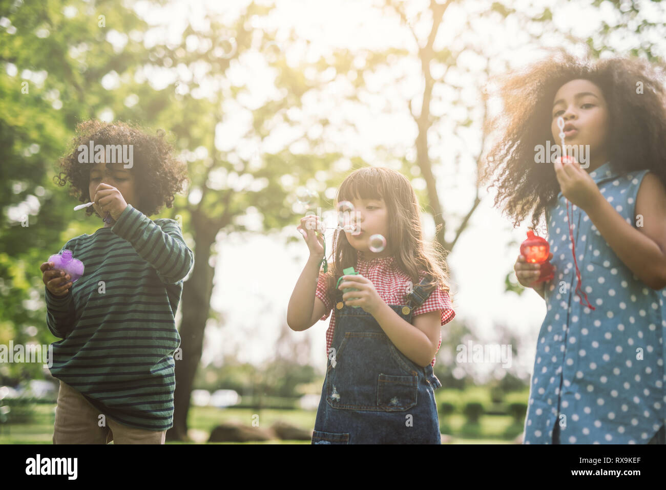 Kids playing Blowing Bubbles Together at the Field Stock Photo - Alamy
