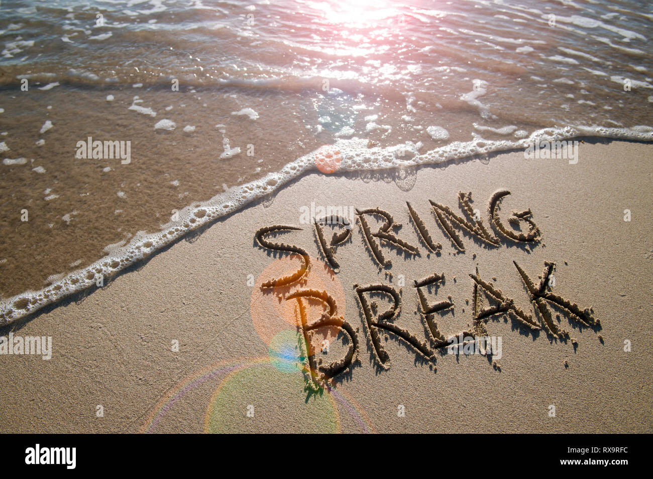 Spring Break message handwritten on the smooth sand of an empty beach ...