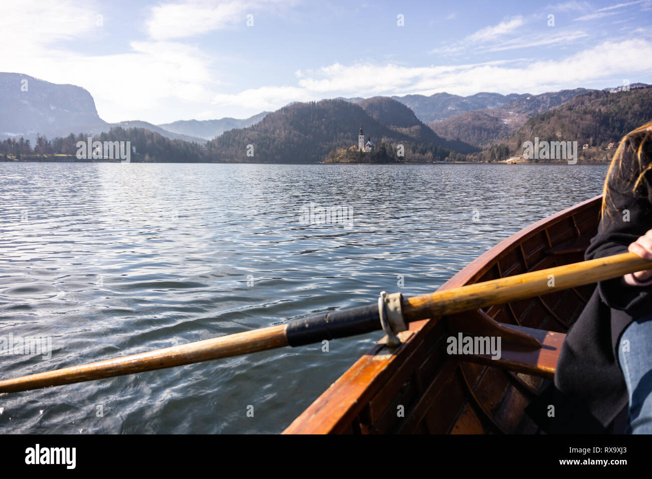 Young woman using paddle on a wooden boat - Lake Bled Slovenia rowing ...