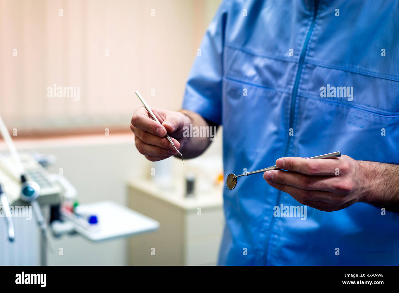 Dentist holding a dental mirror and probe closeup Stock Photo - Alamy