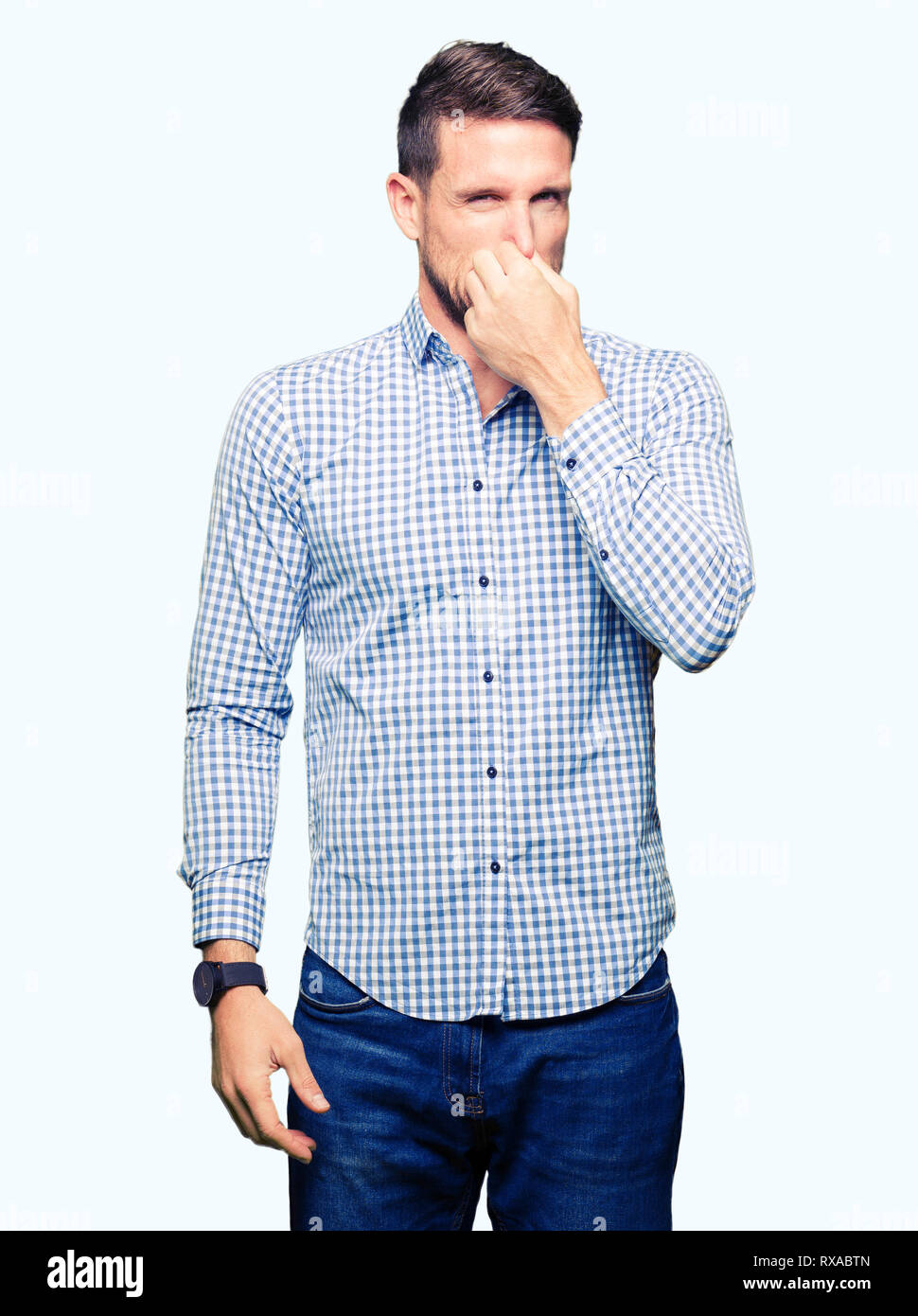 Handsome business man with blue eyes smelling something stinky and ...