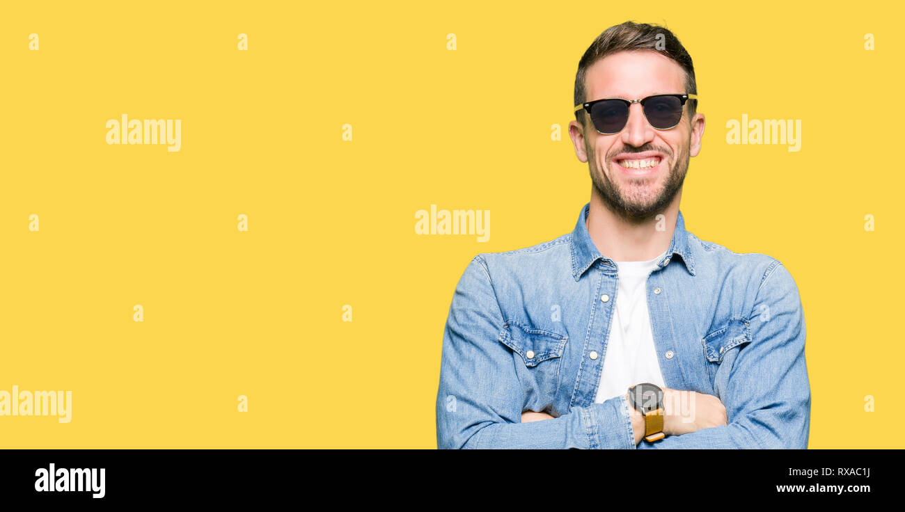Handsome man wearing fashion sunglasses happy face smiling with crossed ...