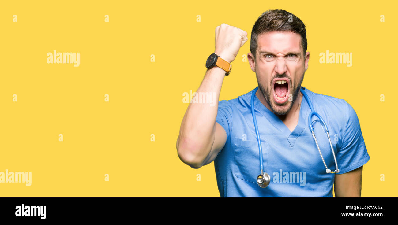 Handsome doctor man wearing medical uniform over isolated background ...