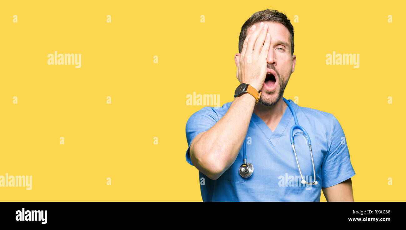 Handsome doctor man wearing medical uniform over isolated background ...