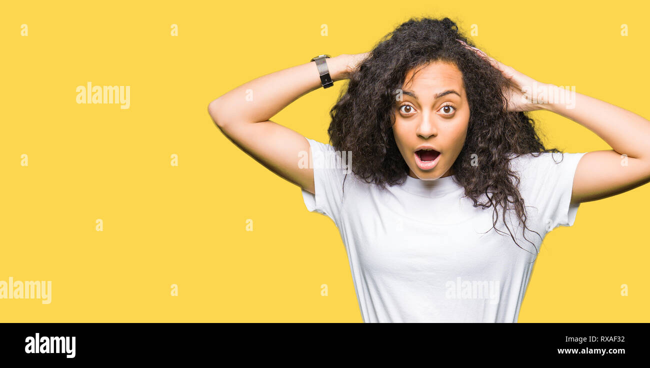 Young beautiful girl with curly hair wearing casual white t-shirt Crazy ...