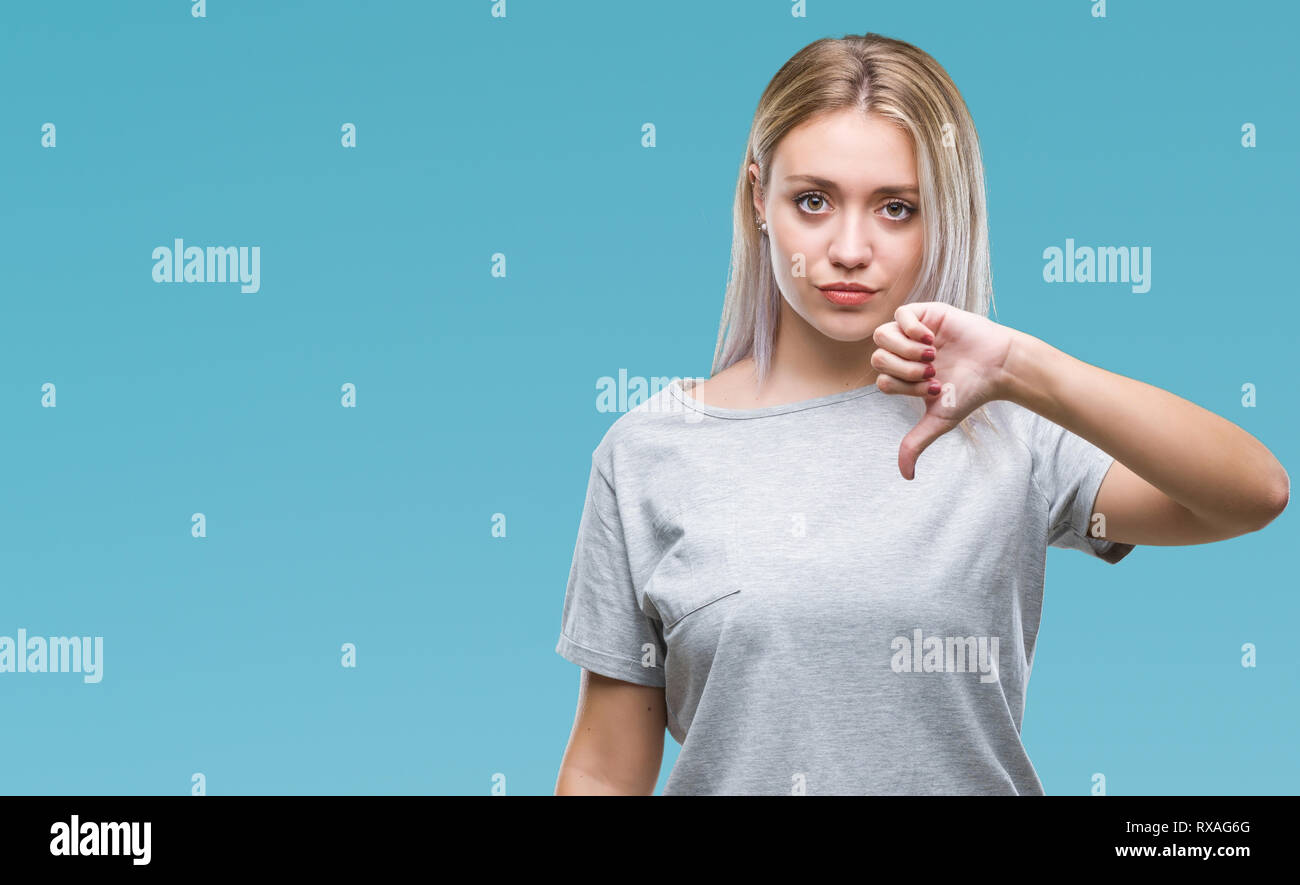 Young blonde woman over isolated background looking unhappy and angry ...