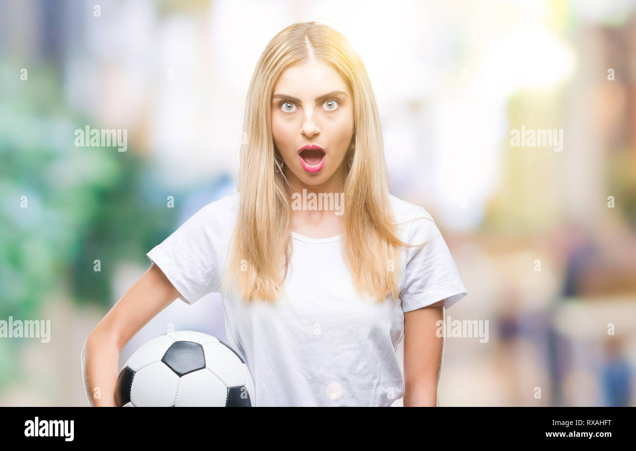 Young beautiful blonde woman holding soccer ball over isolated ...