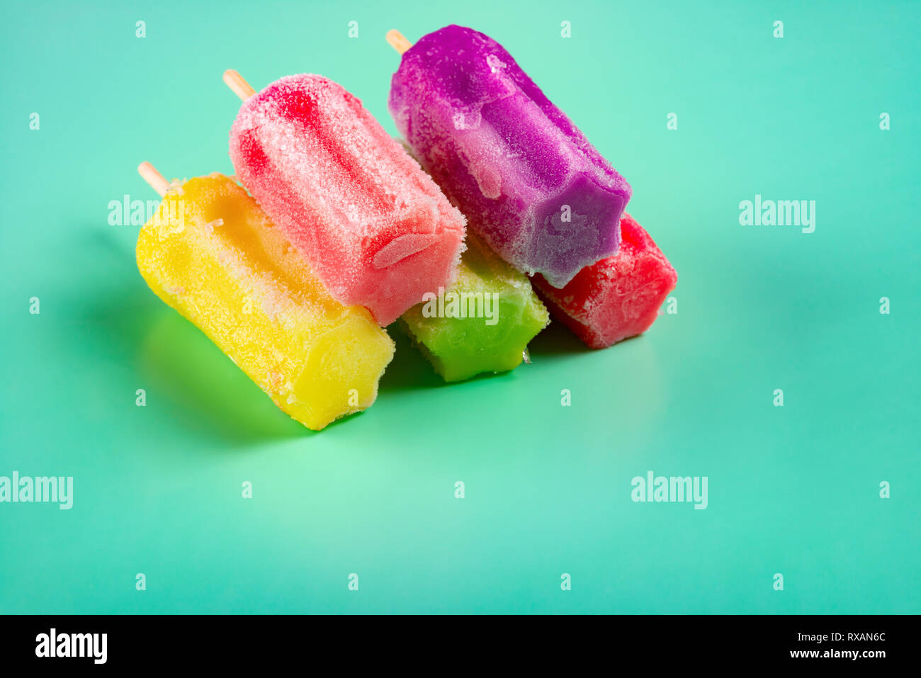 multi-color popsicles line up on green background with copy space Stock ...