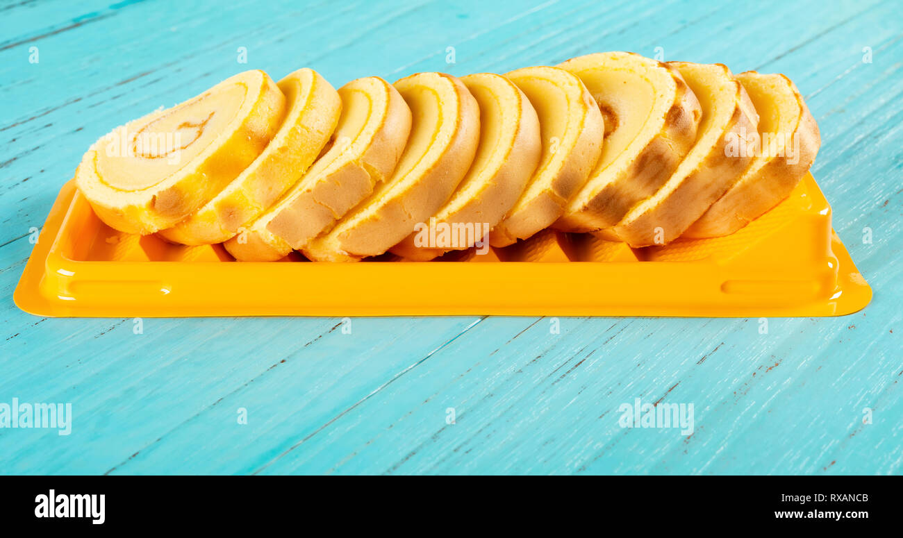 side view golden sweet rolls on a blue wood background Stock Photo - Alamy