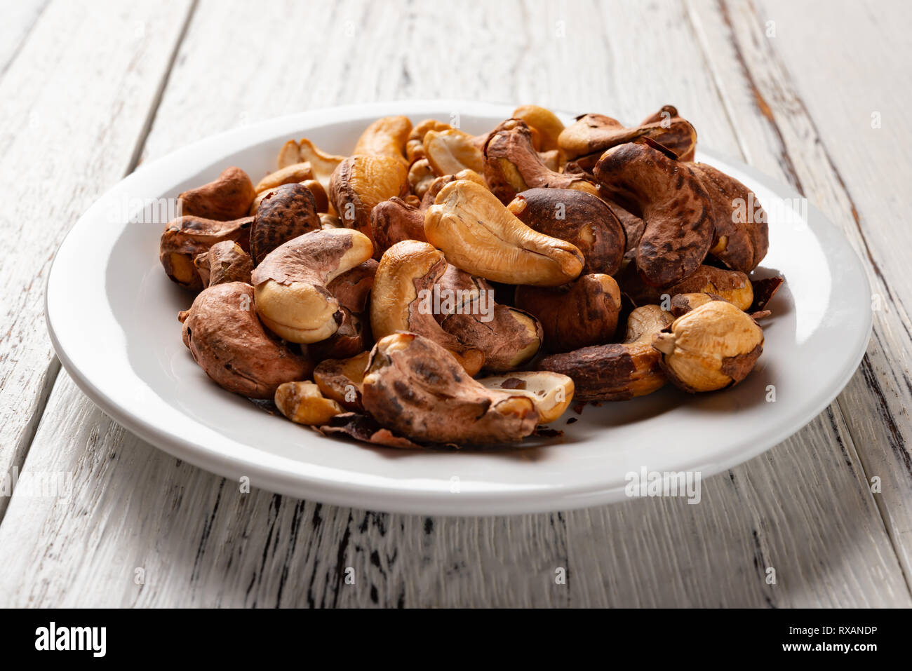 side view cashew nuts on a dish on white wood background Stock Photo ...