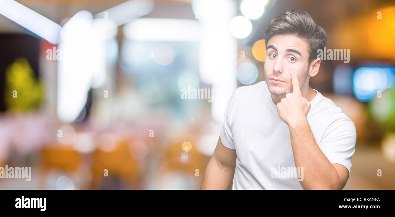 Young handsome man wearing white t-shirt over isolated background ...