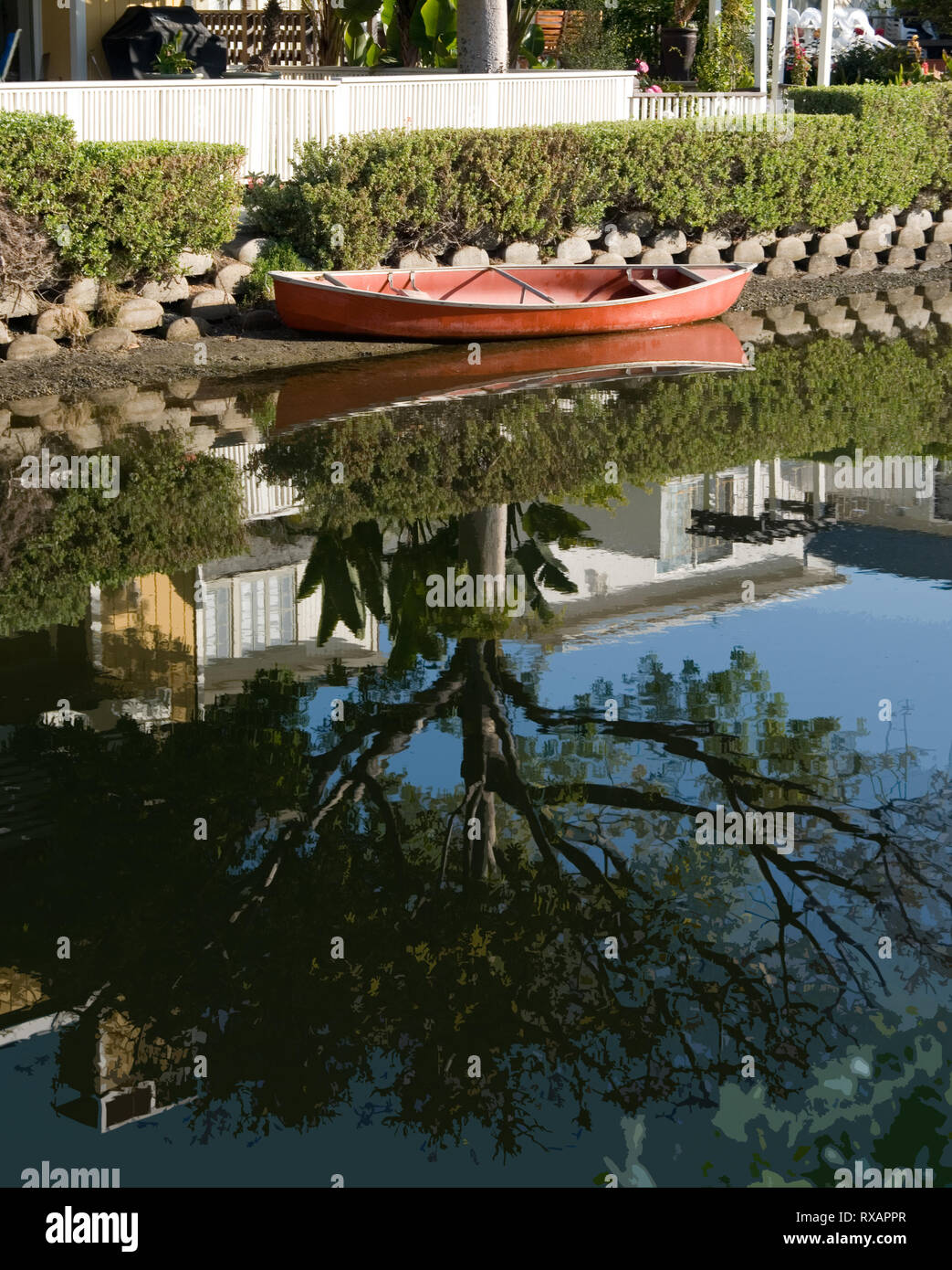 A red rowboat and the reflection of a tree in Venice Canals in Southern ...