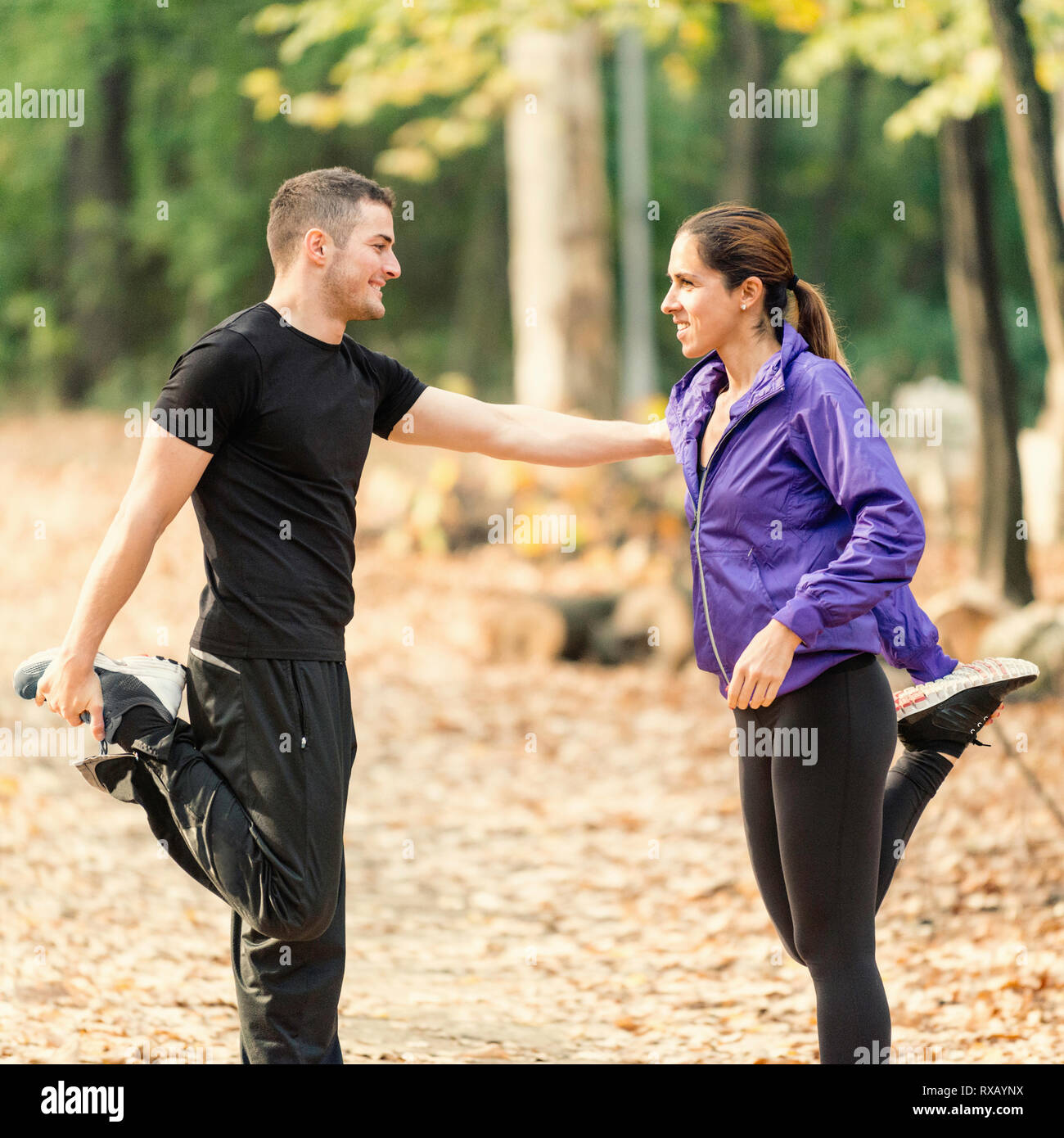 Happy couple exercising in park Stock Photo - Alamy