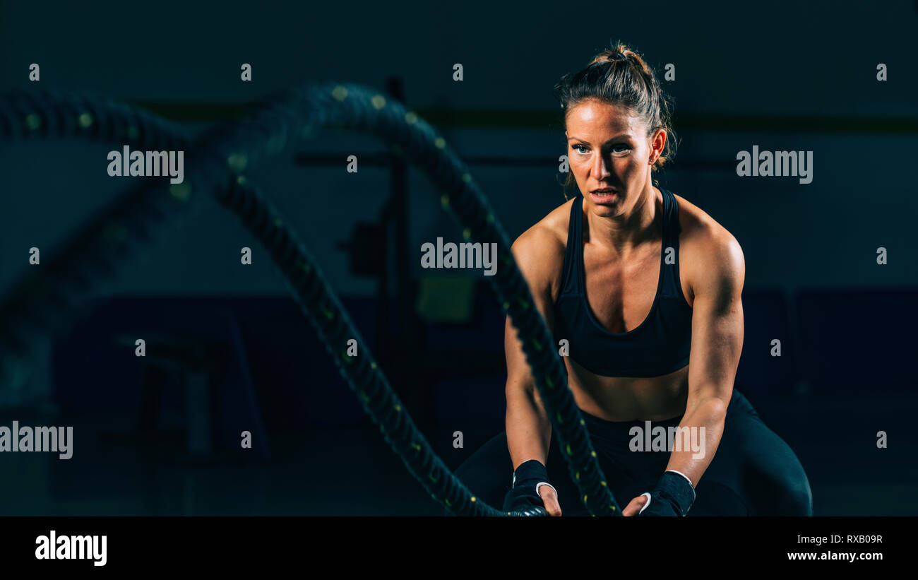 Woman exercising battle ropes hi-res stock photography and images - Alamy