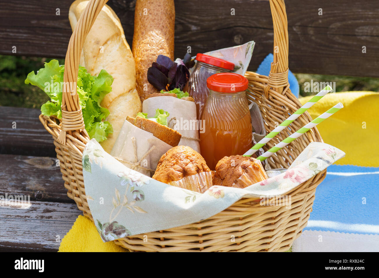 Picnic basket with various food and drinks on a park bench for an ...
