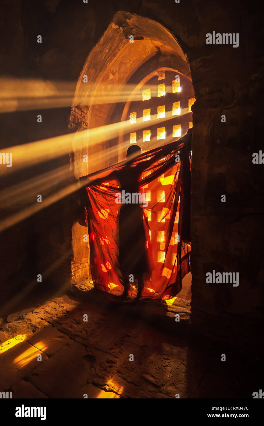 Back side of monk change the robe with sun ray in pagoda at bagan ...