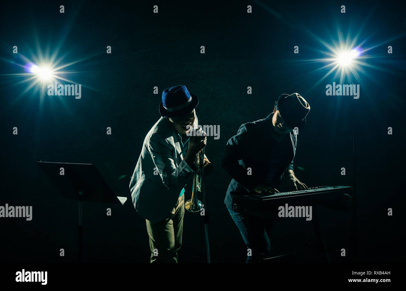 Musician Duo band playing a keyboard and singing on black background ...