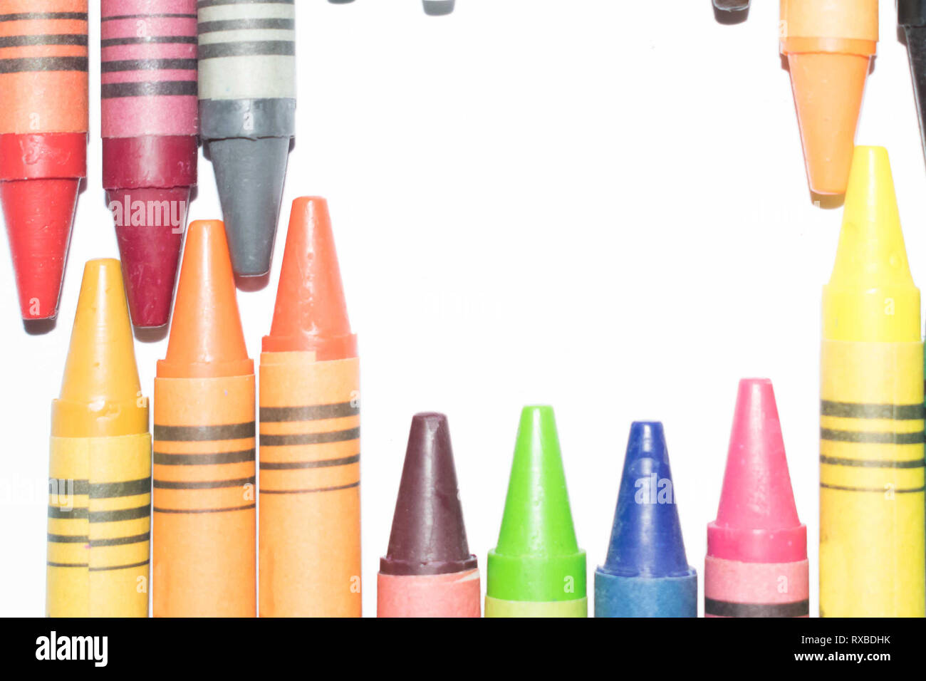Crayons facing each other. Colorful shades of crayons lain a white ...