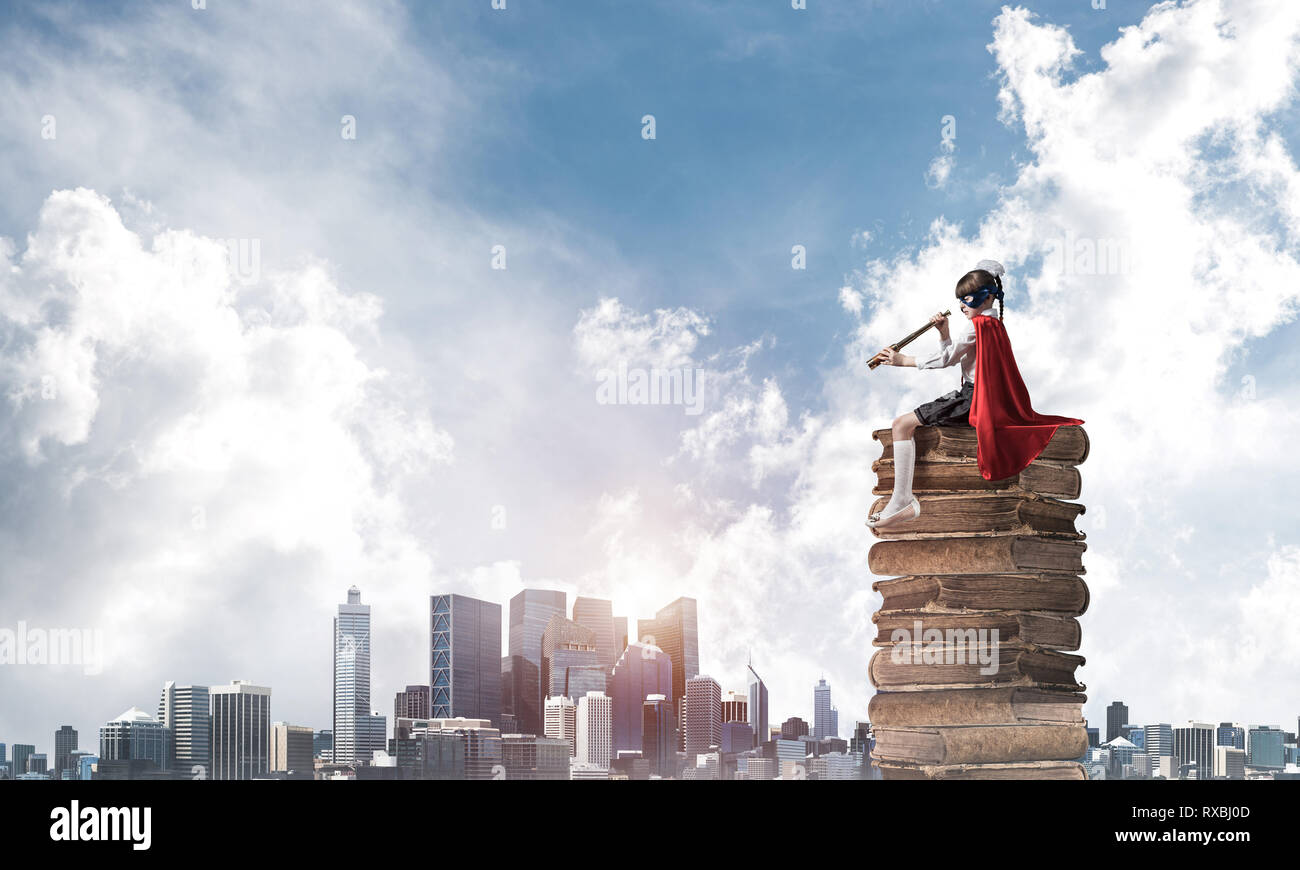 Girl power concept with cute kid guardian against cloudscape background ...
