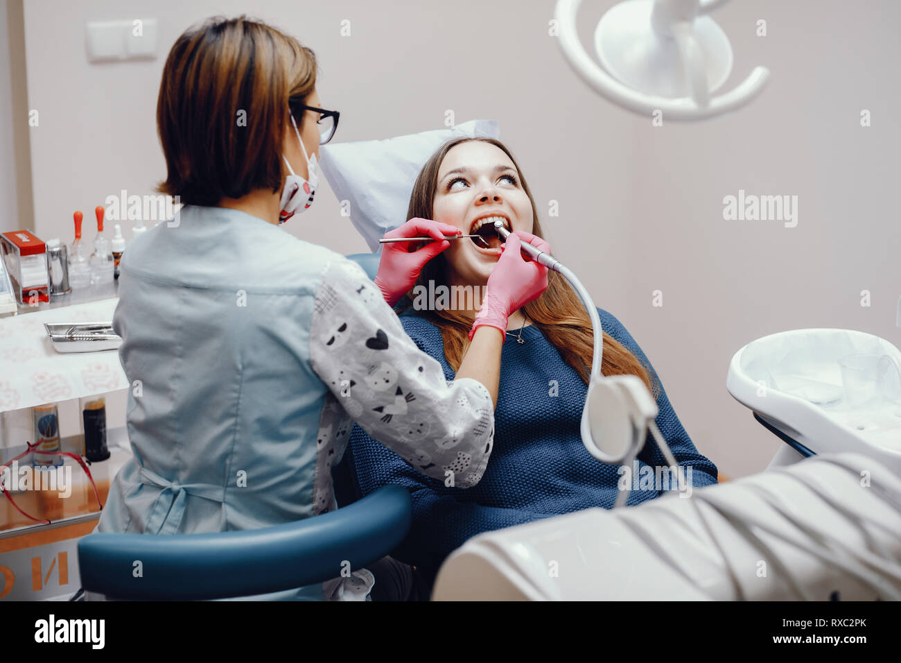 Beautiful girl sitting in the dentist's office Stock Photo - Alamy