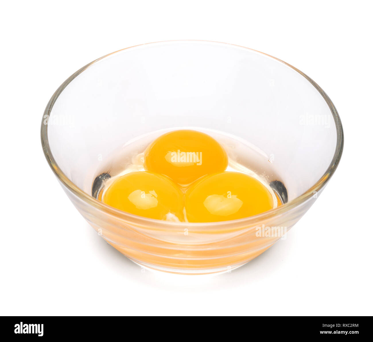 three egg yolk in a glass bowl isolated on white background with ...