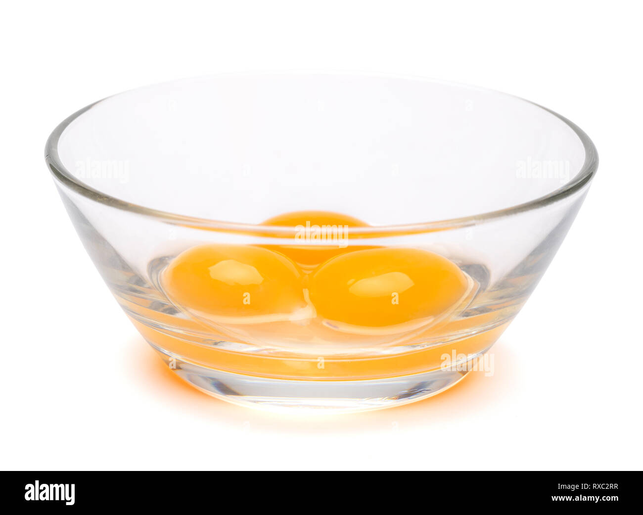 three egg yolk in a glass bowl isolated on white background with ...