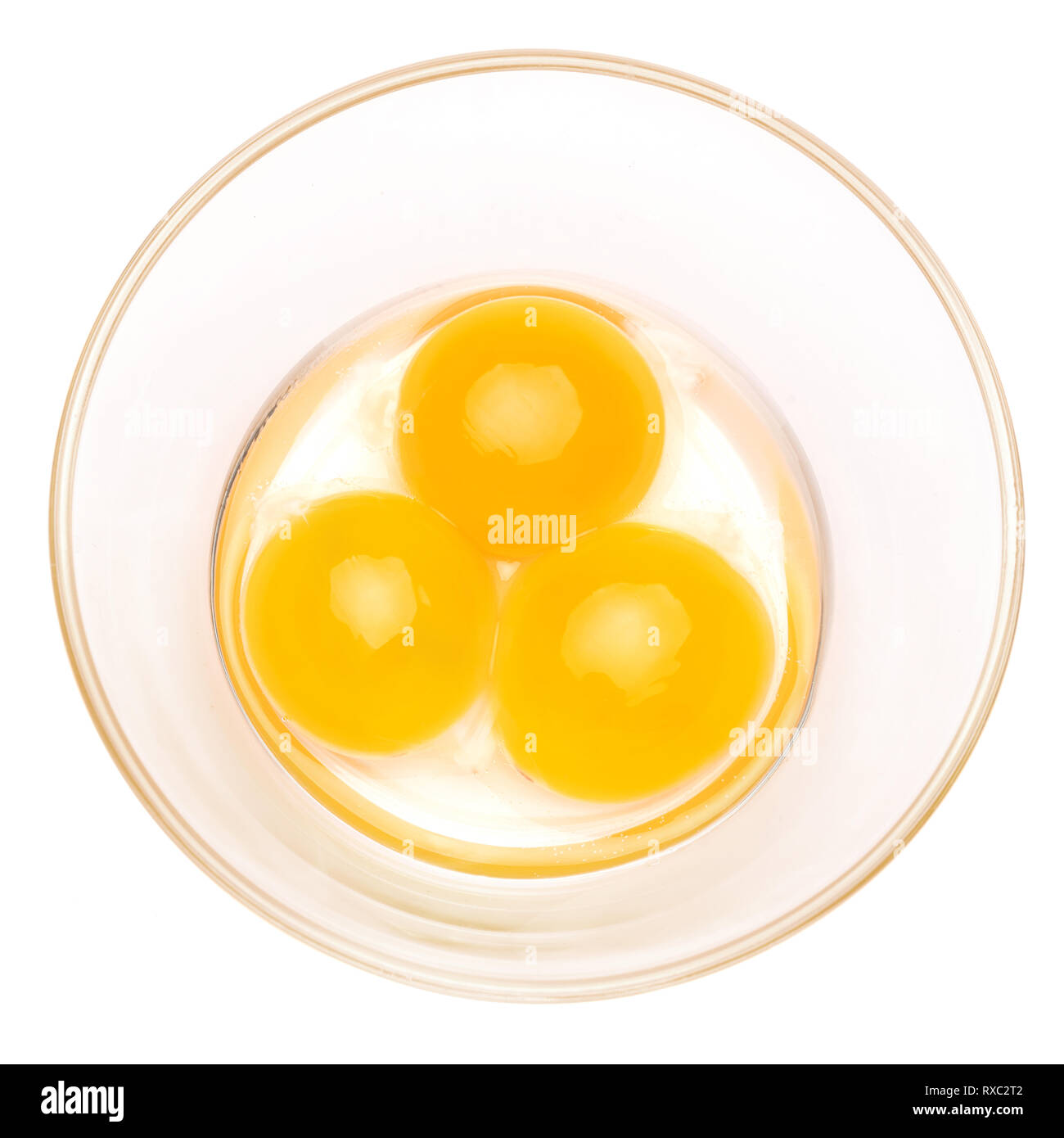 three egg yolk in a glass bowl isolated on white background with ...