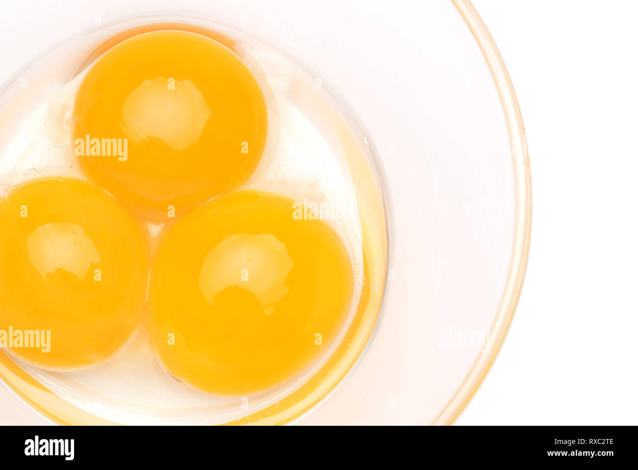 three egg yolk in a glass bowl isolated on white background Stock Photo ...