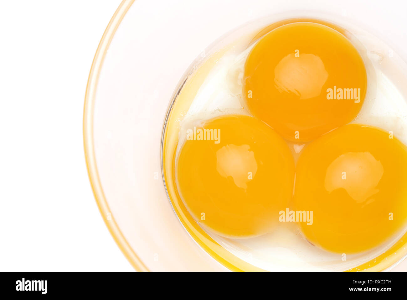 three egg yolk in a glass bowl isolated on white background Stock Photo ...