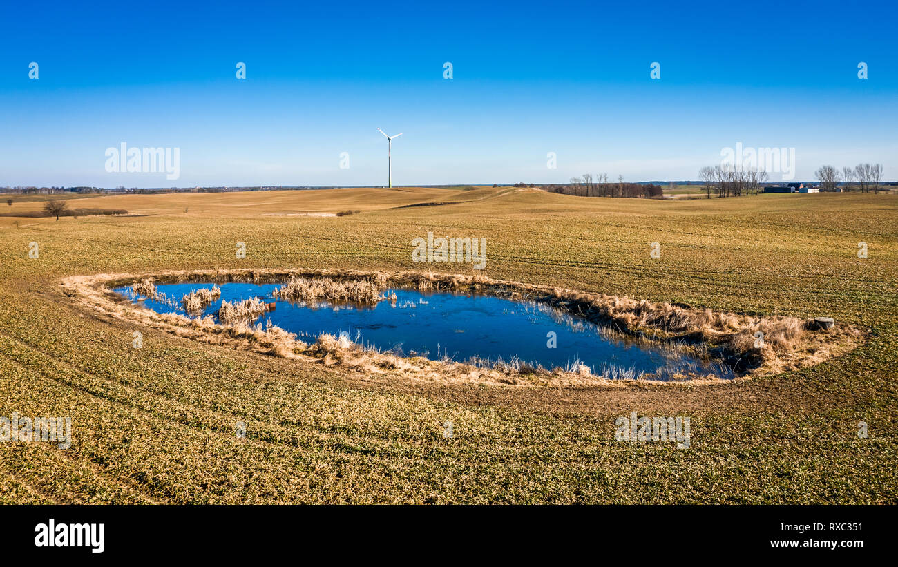 Aerial view of wind turbine on field and small pond Stock Photo - Alamy