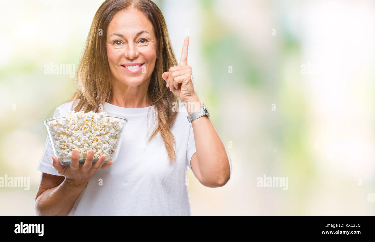 Middle Age Hispanic Woman Eating Popcorn Over Isolated Background