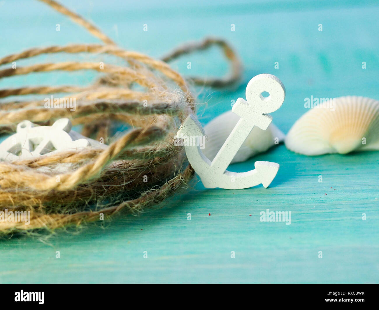 nautical decor with a helm and an anchor, on a white texture, surface ...