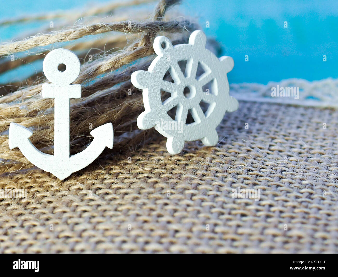 nautical decor with a helm and an anchor, on a white texture, surface ...