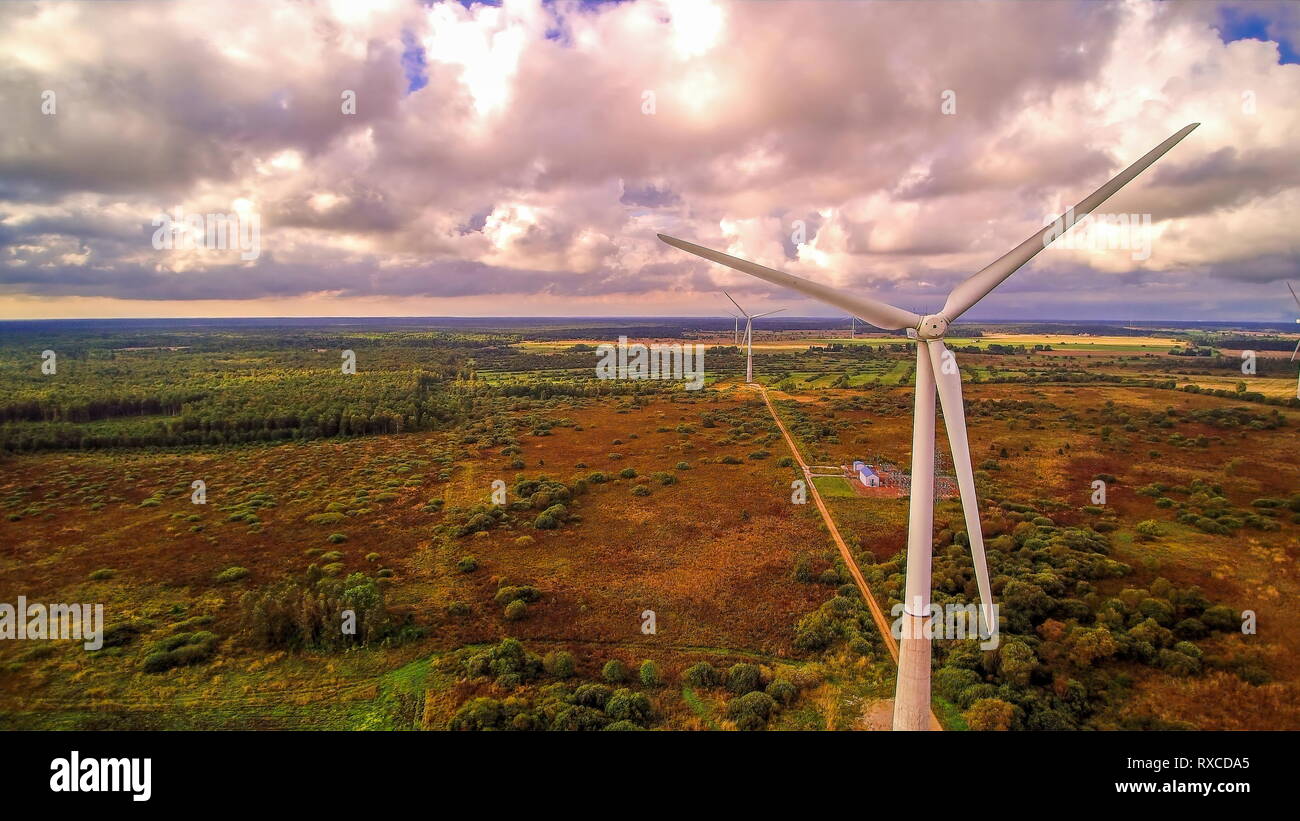 Large white windmills on the field with small roads and small huts on ...