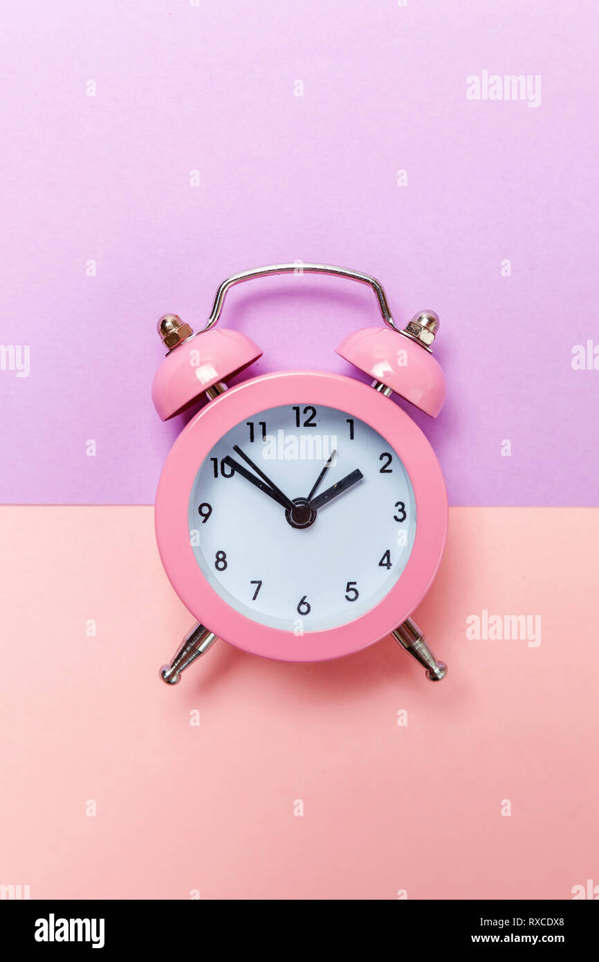Ringing twin bell vintage classic alarm clock Isolated on purple pink ...
