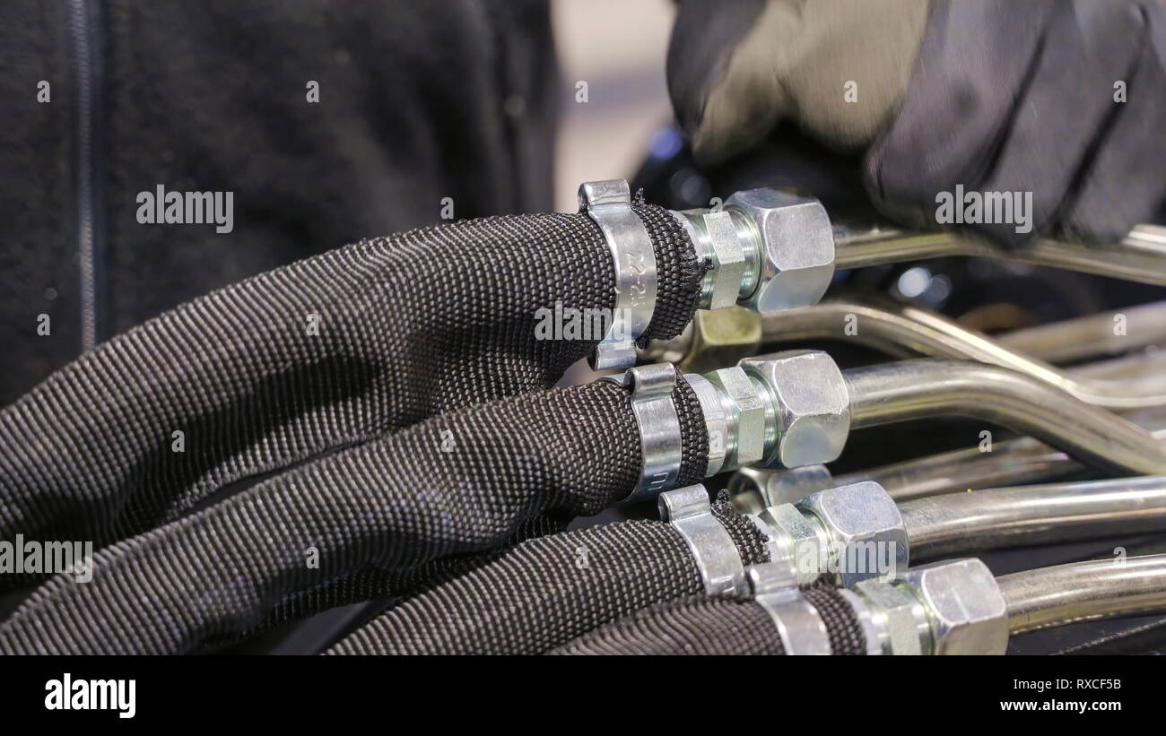 The hydraulic hose being locked by the screw. With the worker locking ...