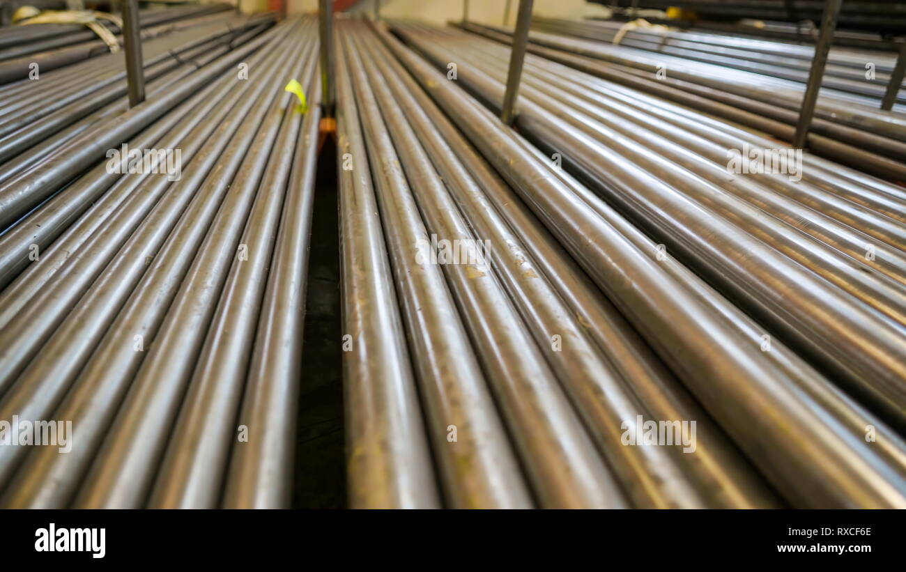 Long metal pipes stored in the room of the steel factory ready for ...