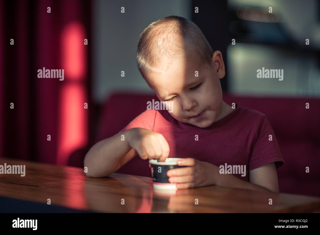 Portrait of a boy eating ice cream. High contrast hard light portrait ...