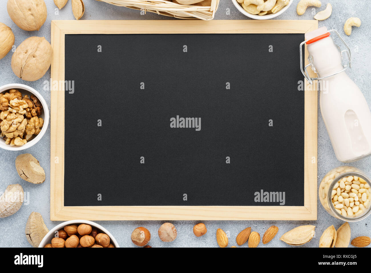 Nut milk and various nuts around chalkboard. Vegan dairy free, no ...
