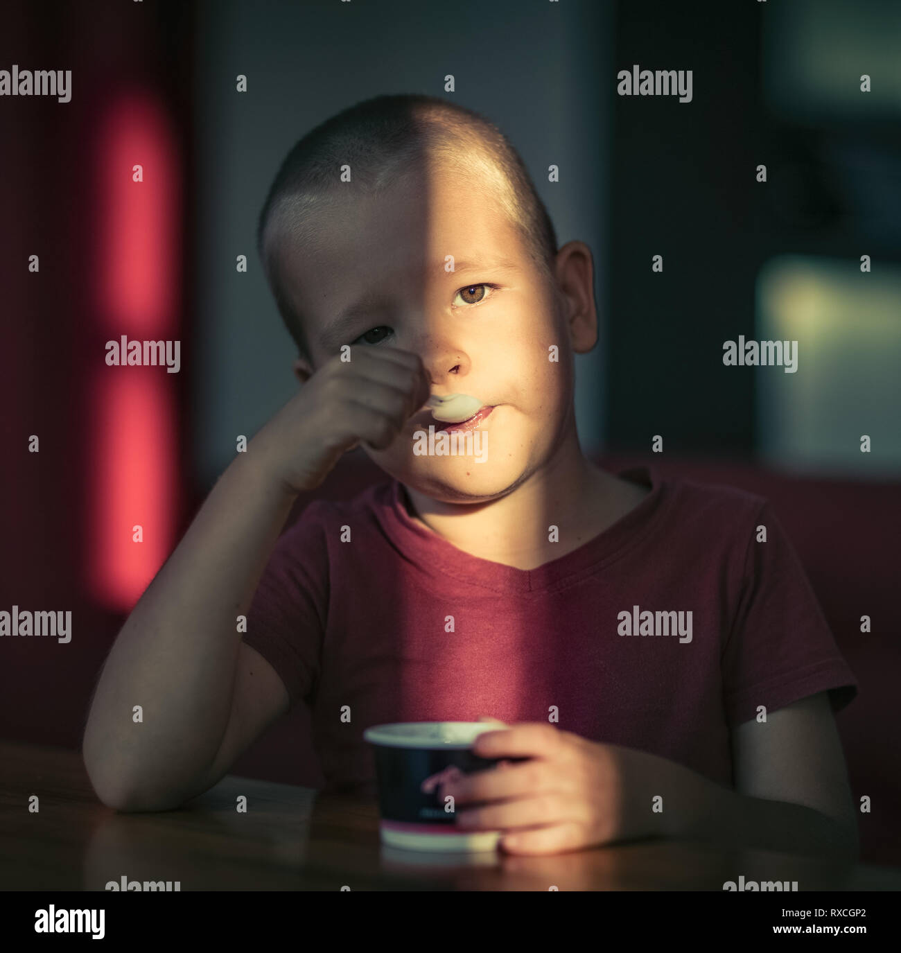 Portrait of a smiling boy eating ice cream. High contrast hard light ...