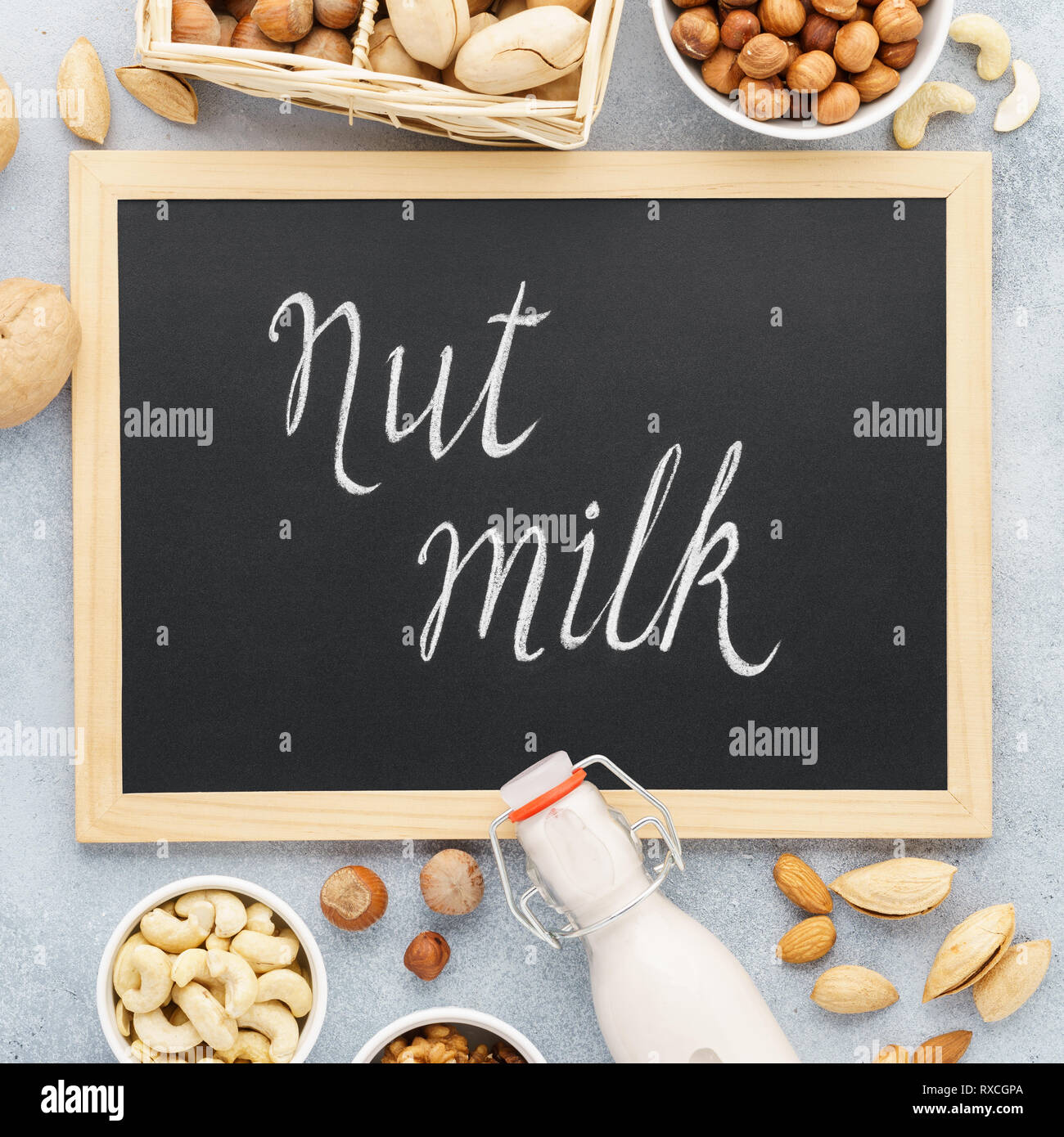 Nut milk and various nuts around chalkboard. Vegan dairy free, no ...