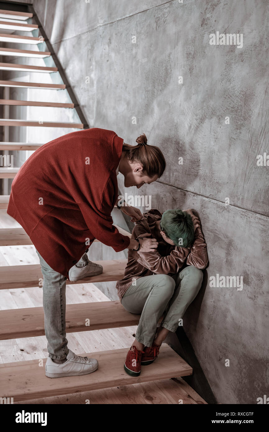 Boyfriend calming his emotional girlfriend sitting on stairs and crying ...