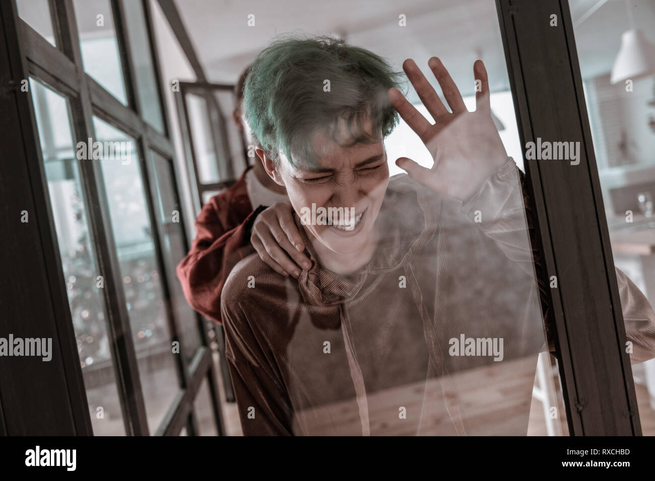 Woman crying standing near door suffering from crazy husband Stock ...