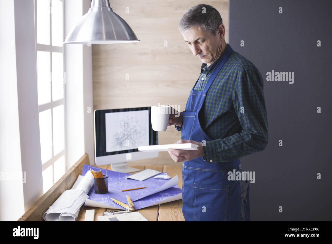 Engineer carpenter working on laptop and sketching project Stock Photo ...