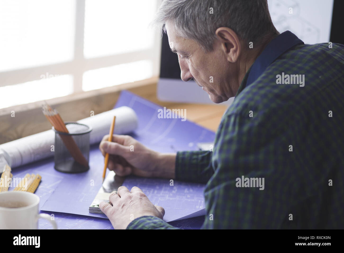 Engineer carpenter working on laptop and sketching project Stock Photo ...