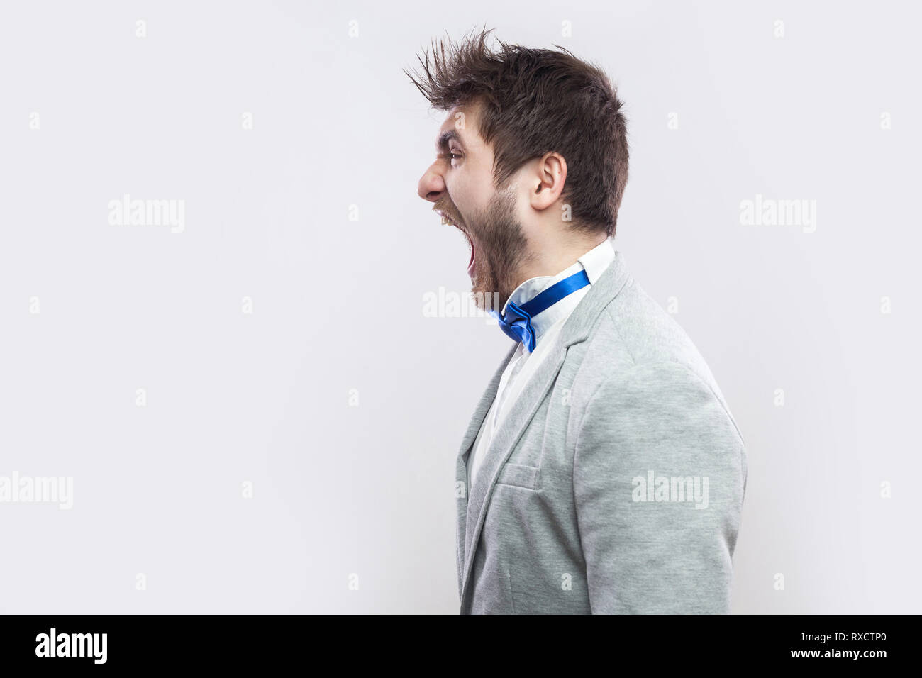 Profile side view portrait of angry handsome bearded man in casual grey ...